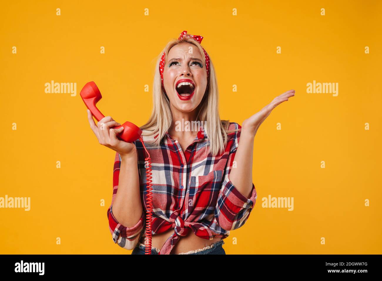 Image of furious pinup girl screaming while posing with handset ...