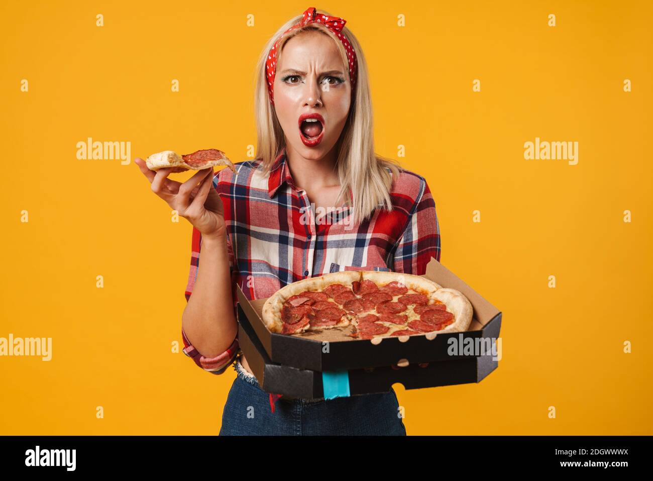 Image of angry charming pinup girl eating pizza on camera isolated over ...