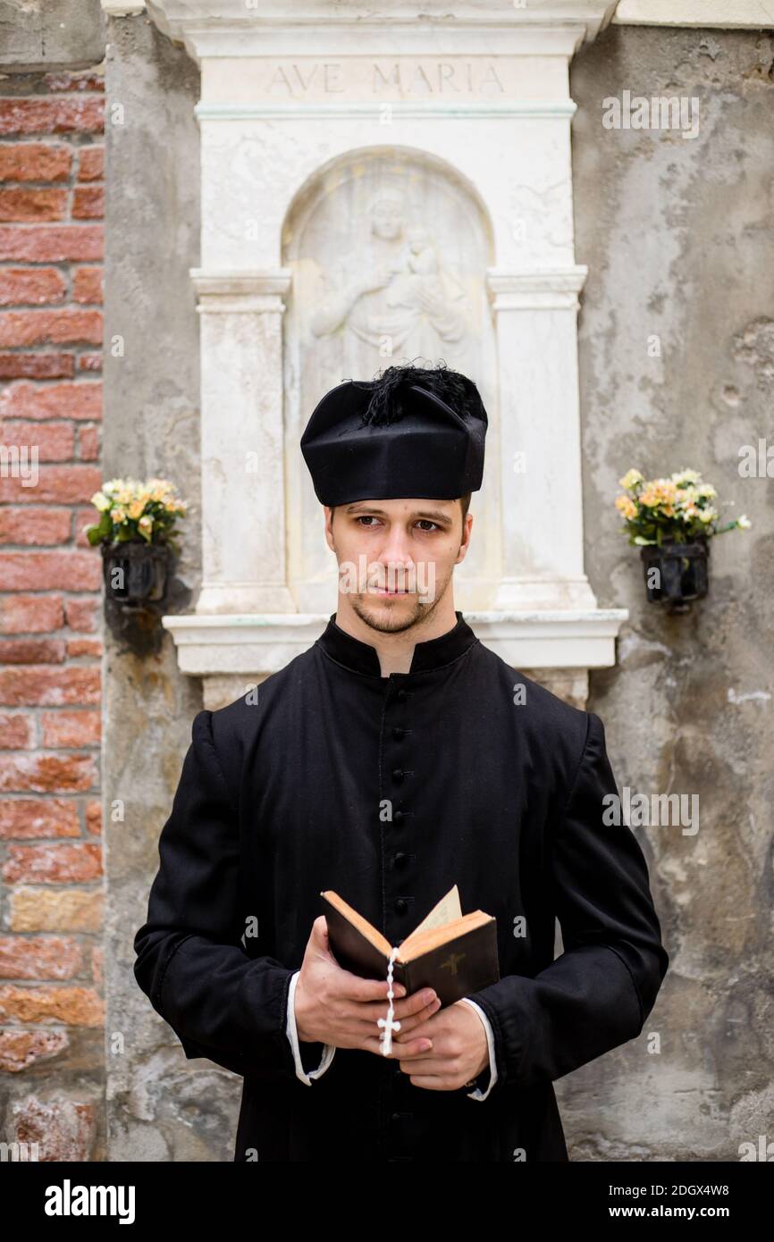 young priest in venice with church Stock Photo - Alamy