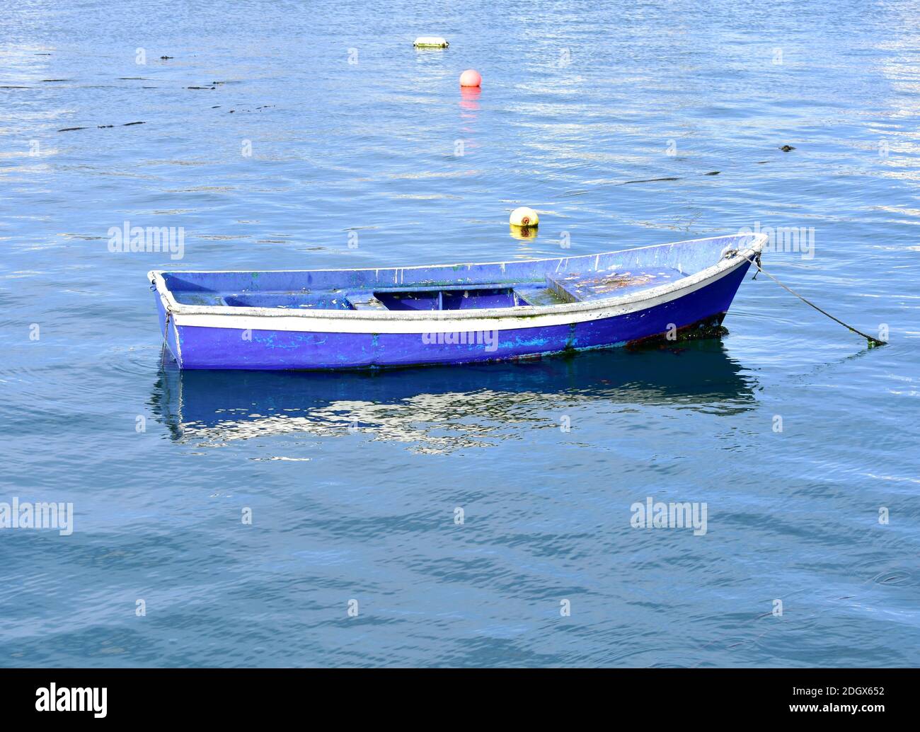 Old blue and white wooden small fishing boat floating on the sea at ...