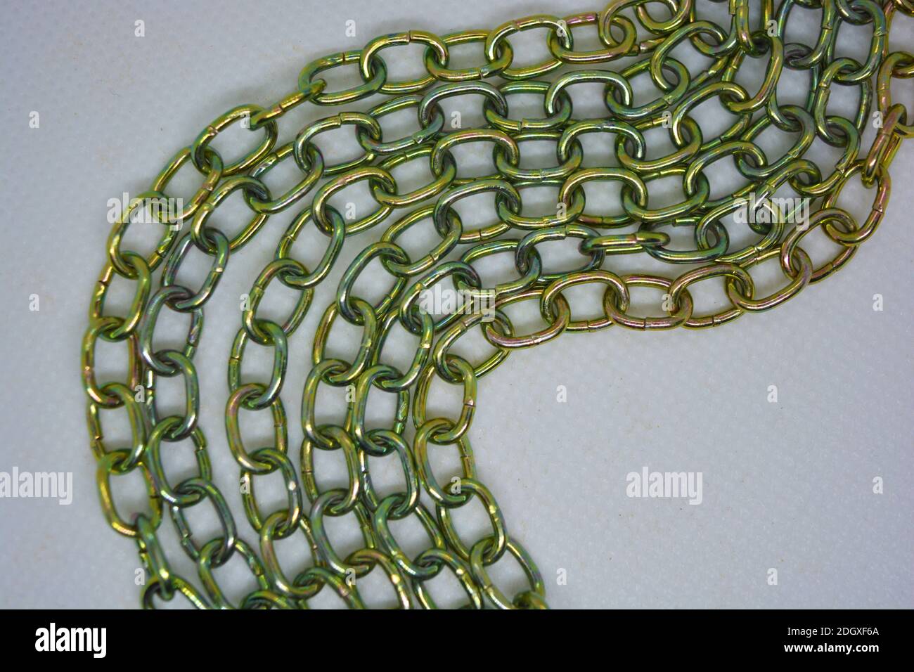 Metal chains, overflow chains are arranged randomly on a white fabric ...