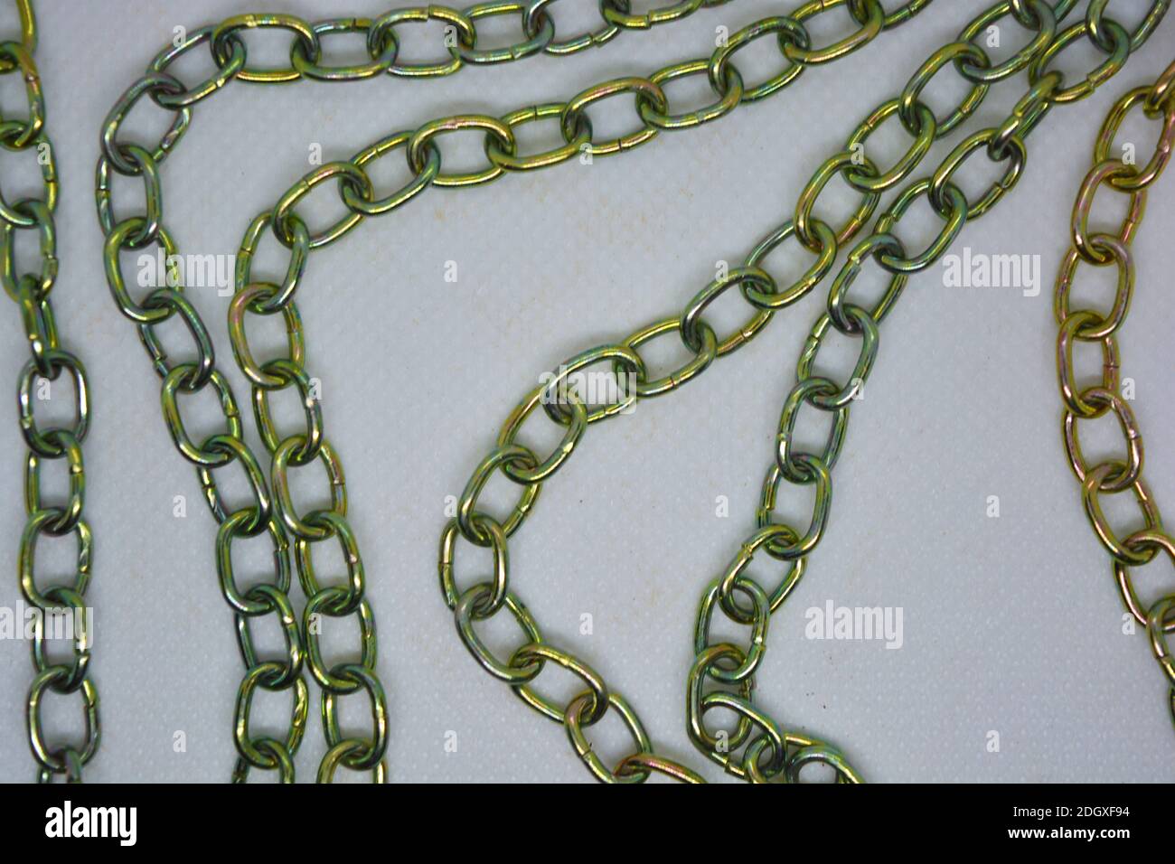 Metal chains, overflow chains are arranged randomly on a white fabric ...