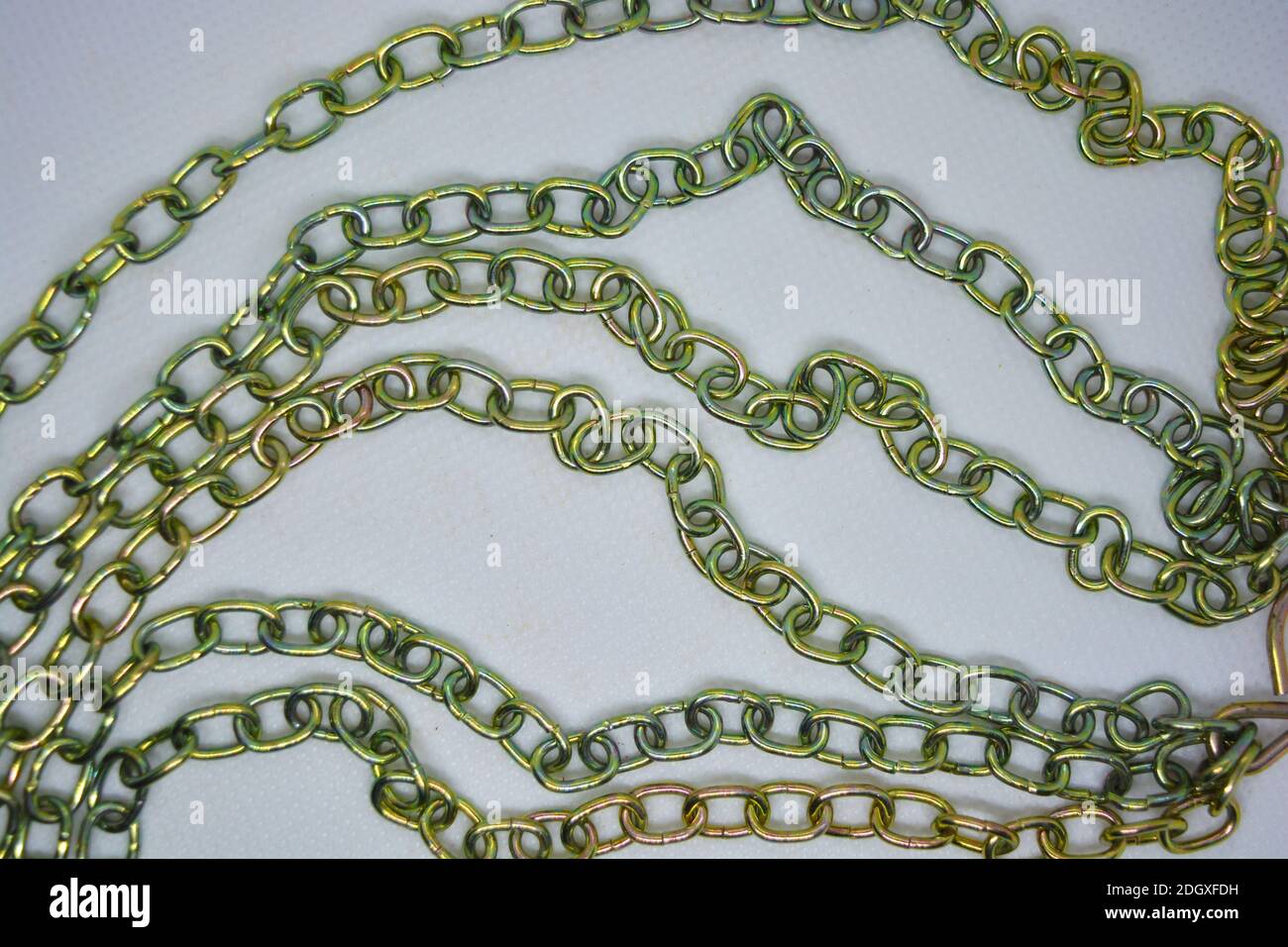 Metal chains, overflow chains are arranged randomly on a white fabric ...