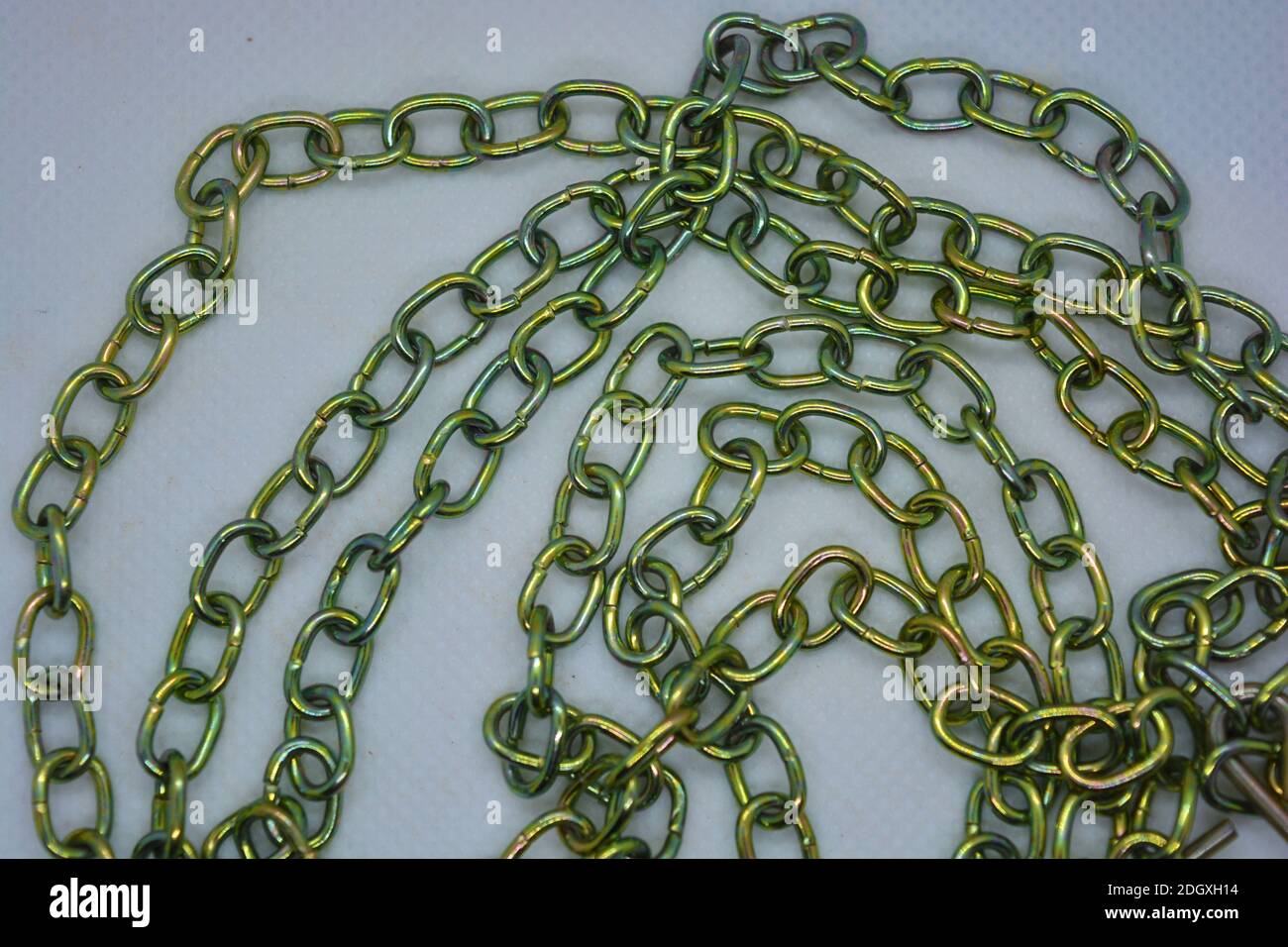 Metal chains, overflow chains are arranged randomly on a white fabric ...
