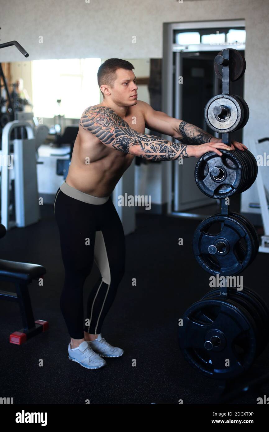 side view. young bodybuilder in the gym Stock Photo - Alamy
