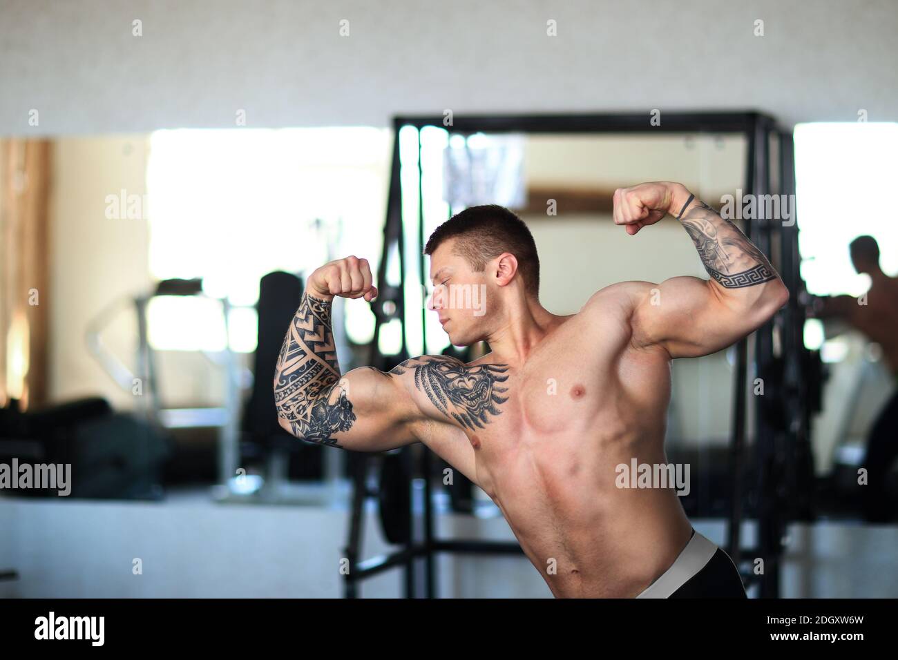 attractive young bodybuilder posing in a modern gym Stock Photo - Alamy