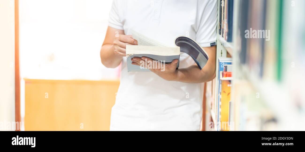 The male hand holding and reading the book for research and education ...