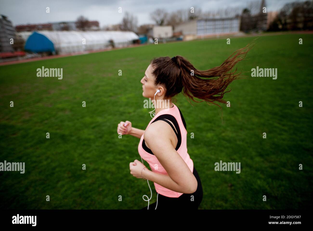 Close up side view of fitness attractive girl jogging on the soccer ...