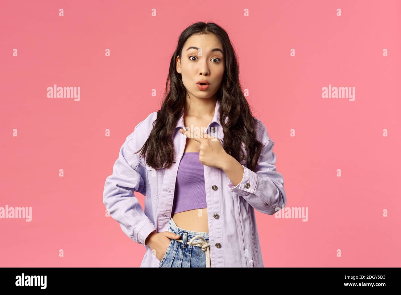 Portrait of surprised and curious young stylish female student pointing ...