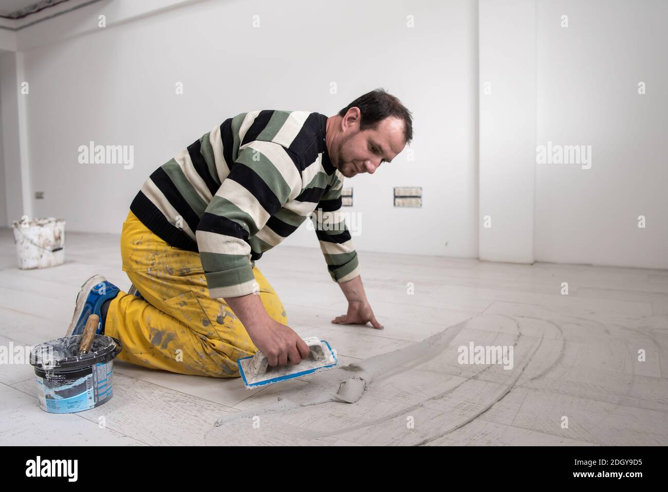 Tilers filling the space between ceramic wood effect tiles Stock Photo ...