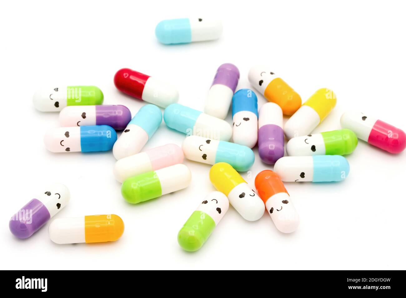 Closeup on medical capsules and pills with happy smiling faces on white ...