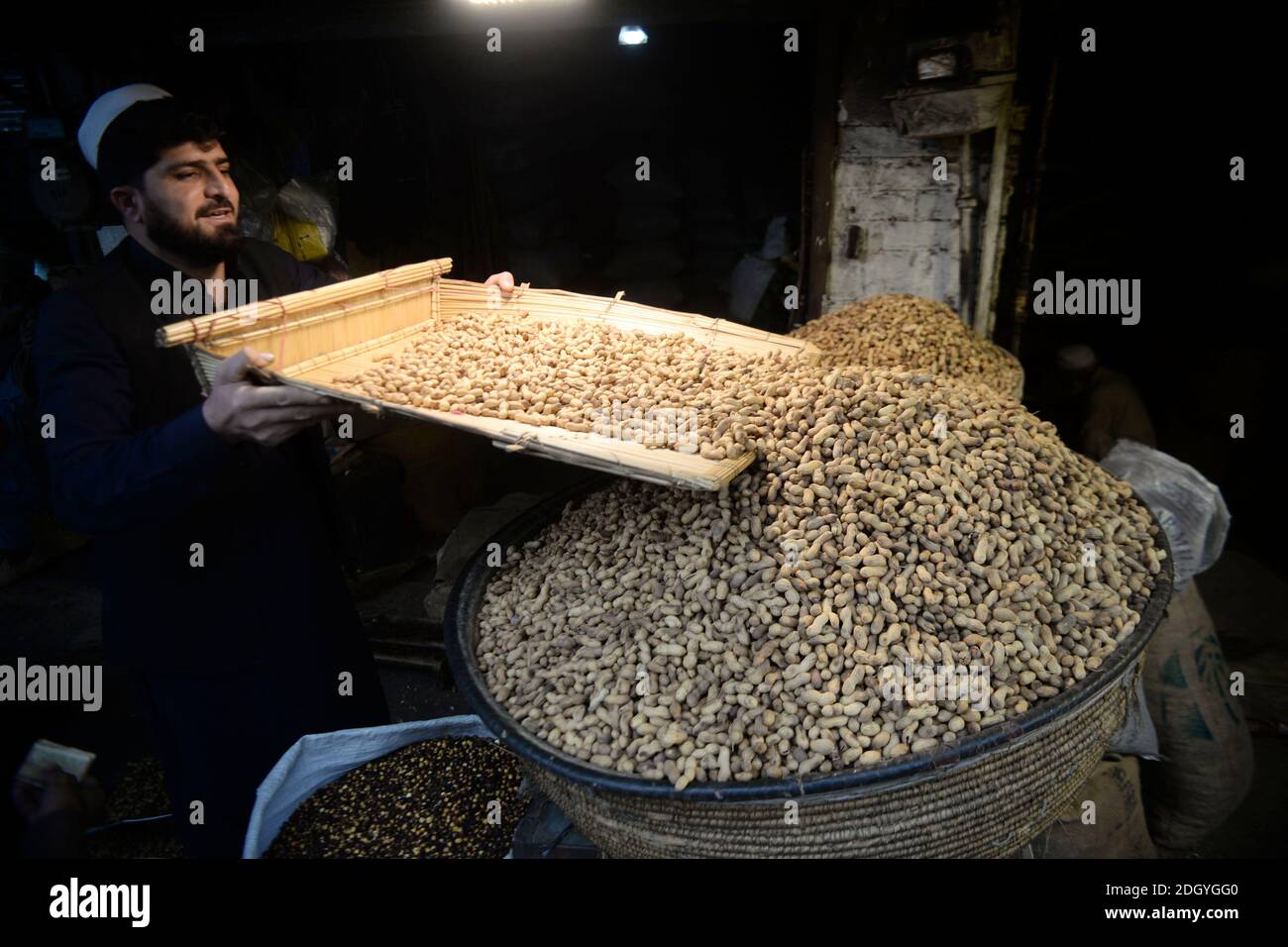 Peshawar. 9th Dec, 2020. A vendor arranges peanuts at a shop in ...