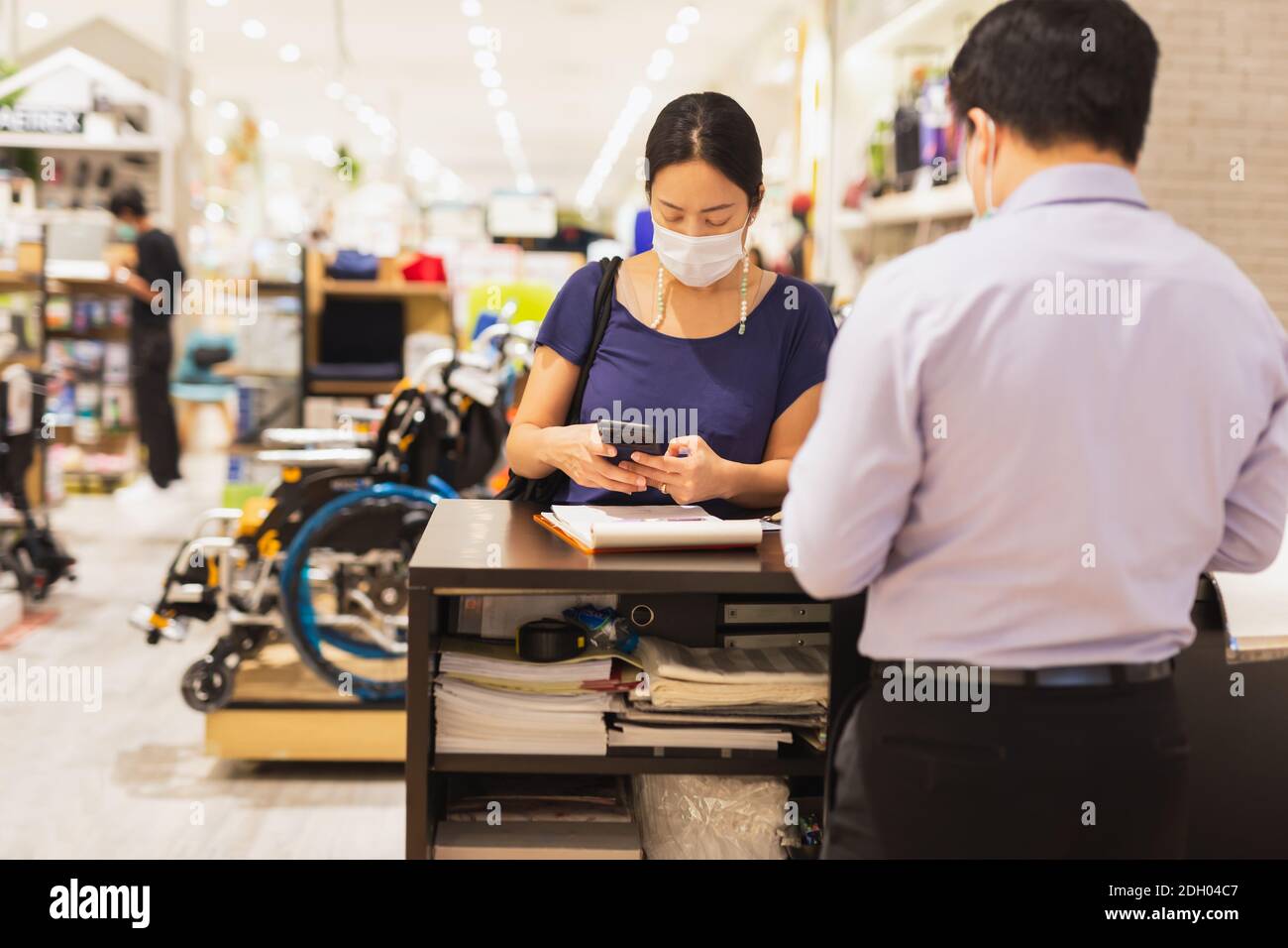 Customer in protective mask make contactless payment with cell phone in ...