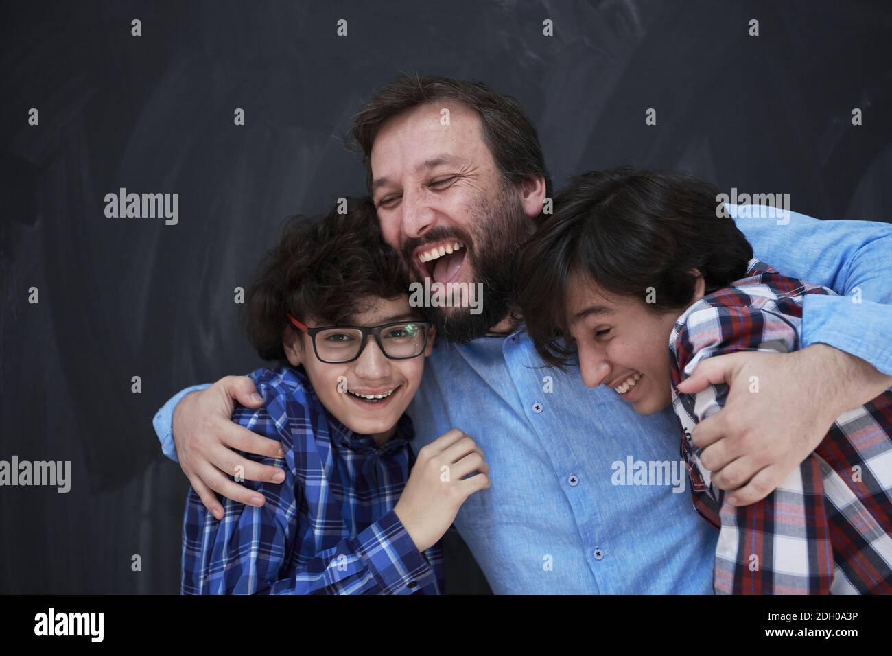 Happy father hugging sons Stock Photo - Alamy