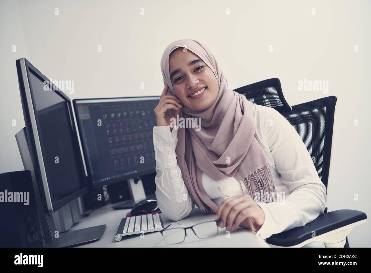 Arabic creative professional working at home office on desktop computer ...