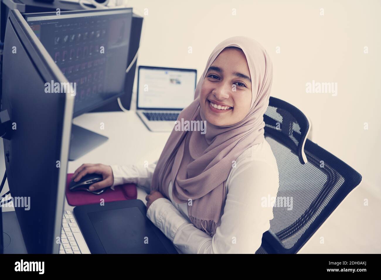 Arabic creative professional working at home office on desktop computer ...