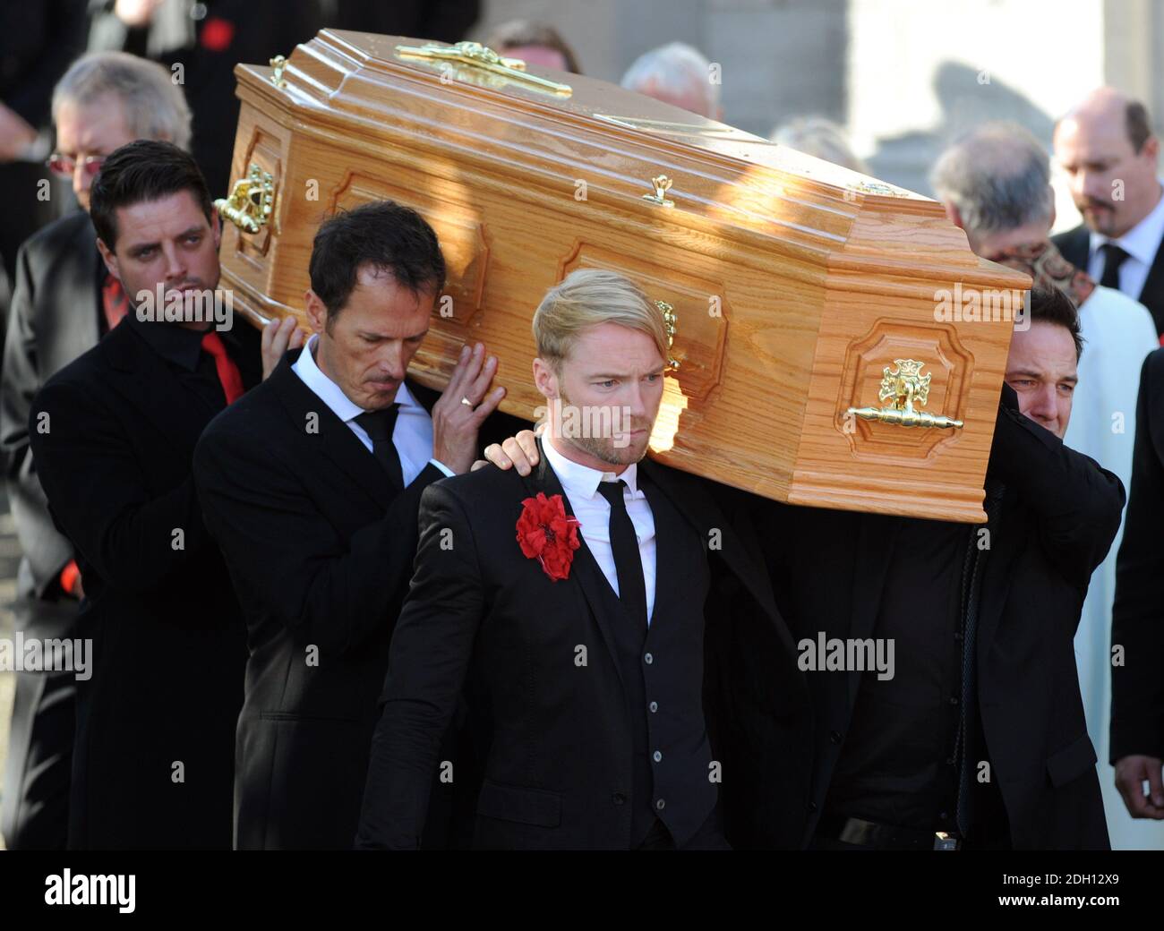 The coffin is brought out of the church by Ronan Keating, Mikey Graham ...
