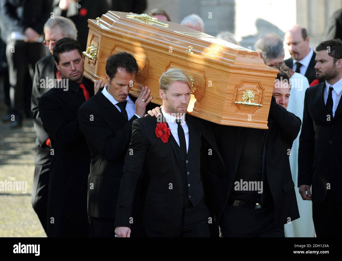 The coffin is brought out of the church by Ronan Keating, Mikey Graham ...