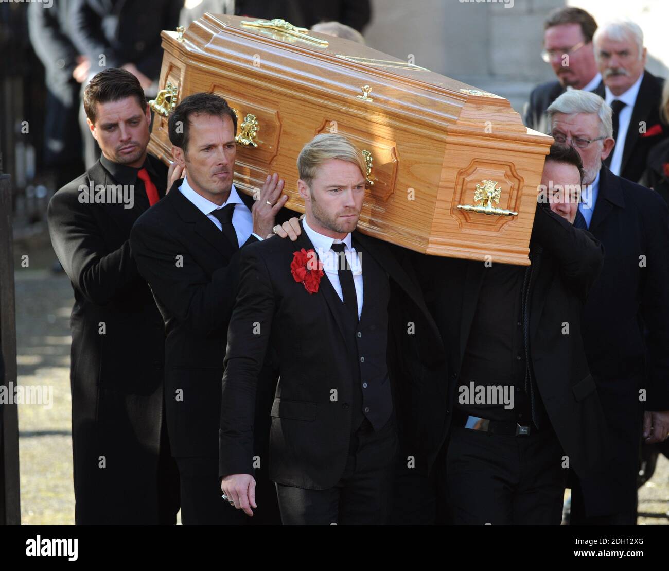 The coffin is brought out of the church by Ronan Keating, Mikey Graham ...