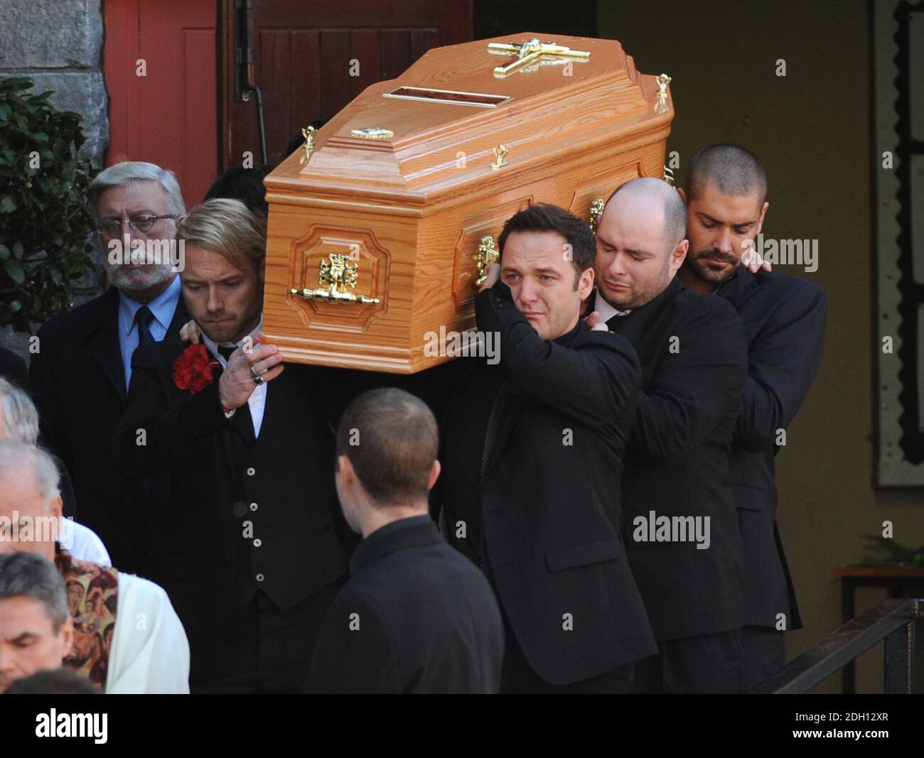 The coffin is brought out of the church by Ronan Keating, Mikey Graham ...