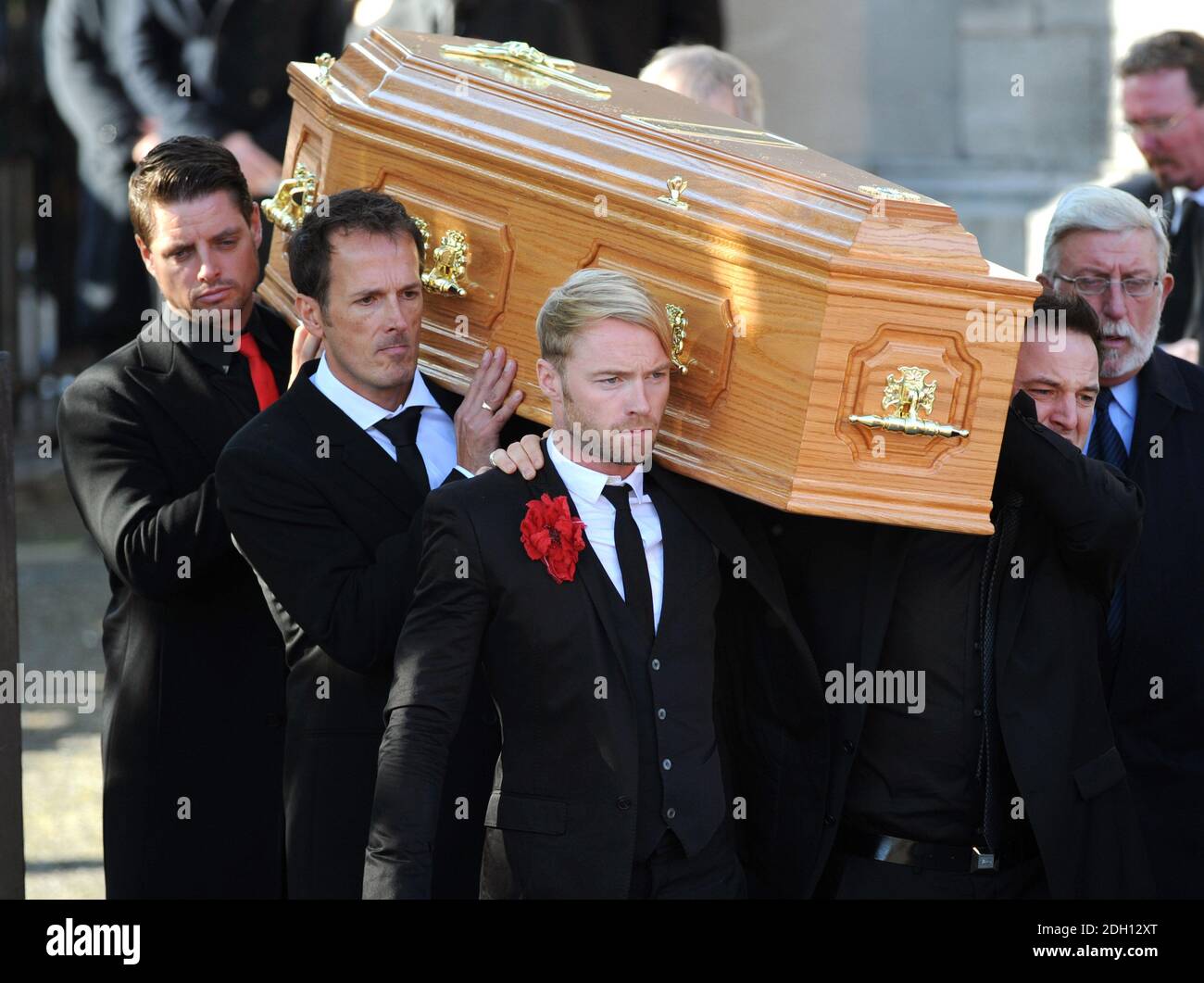 The coffin is brought out of the church by Ronan Keating, Mikey Graham ...
