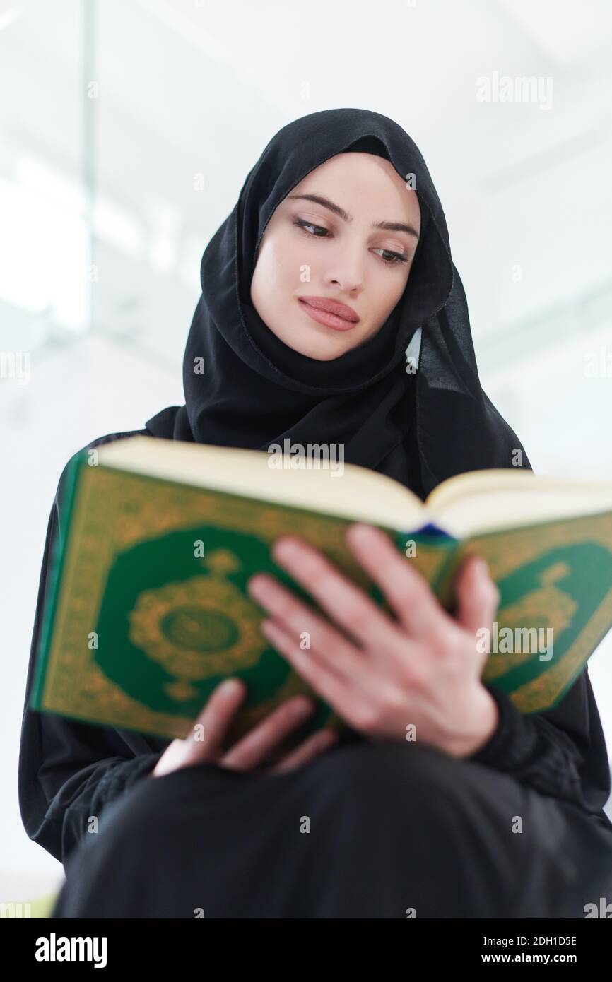 Young muslim woman reading Quran at home Stock Photo - Alamy