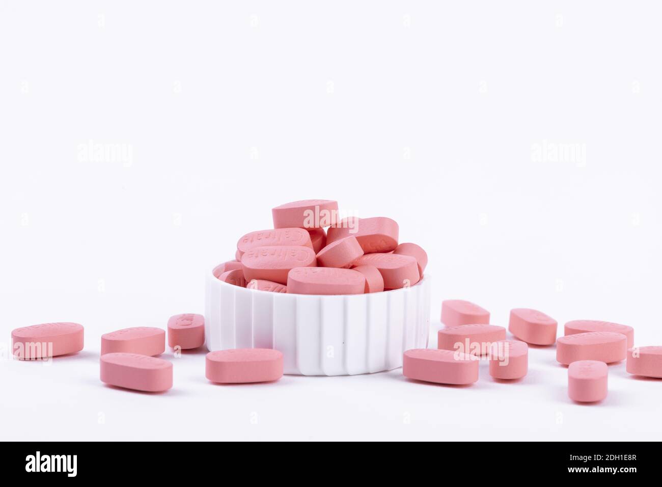 A closeup shot of pink pharmaceuticals on a container an white ...