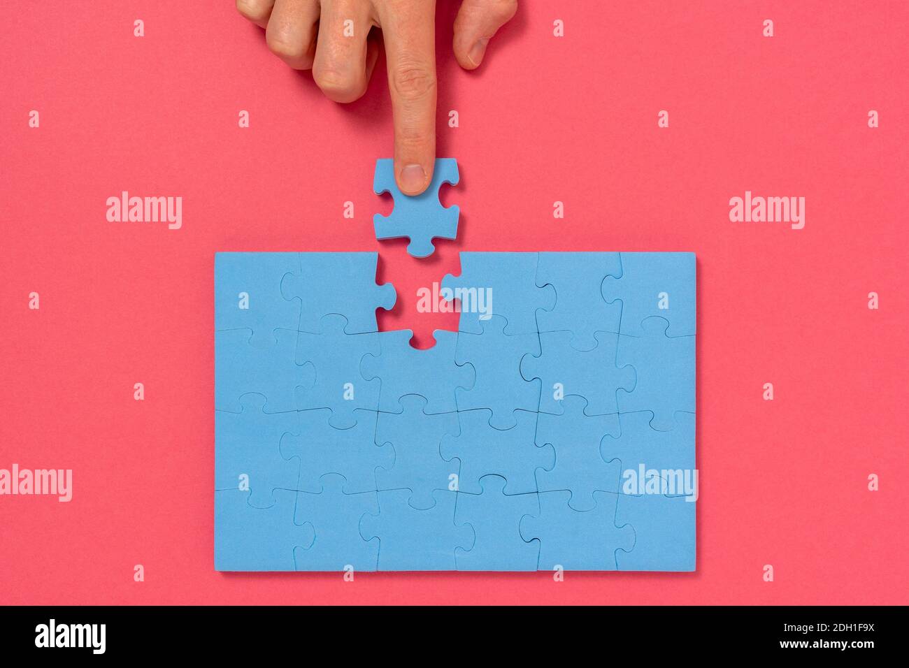 Hand put the last piece of jigsaw puzzle to complete the mission ...