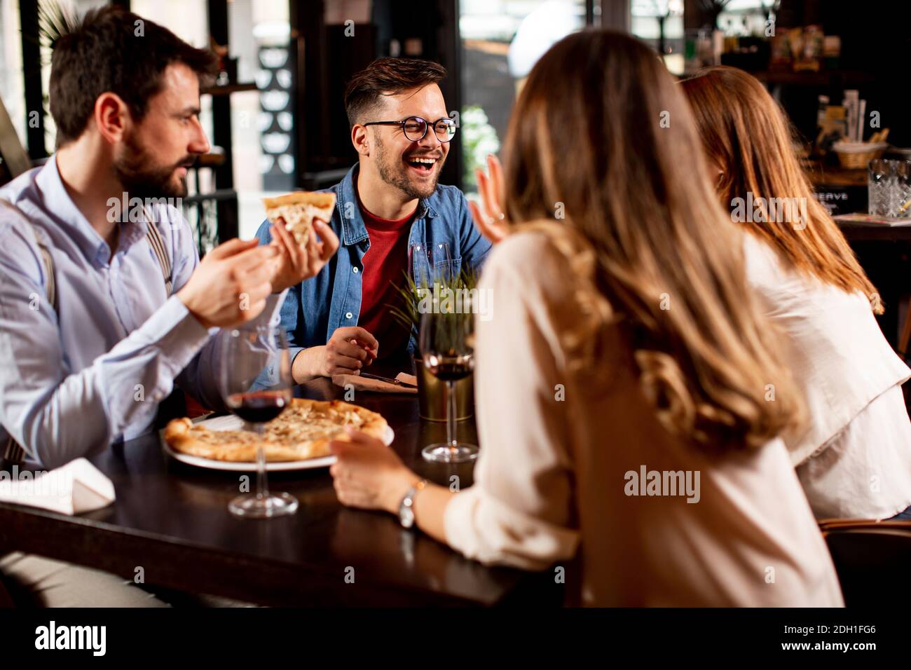 Group of young people having dinner in the restaurant Stock Photo - Alamy