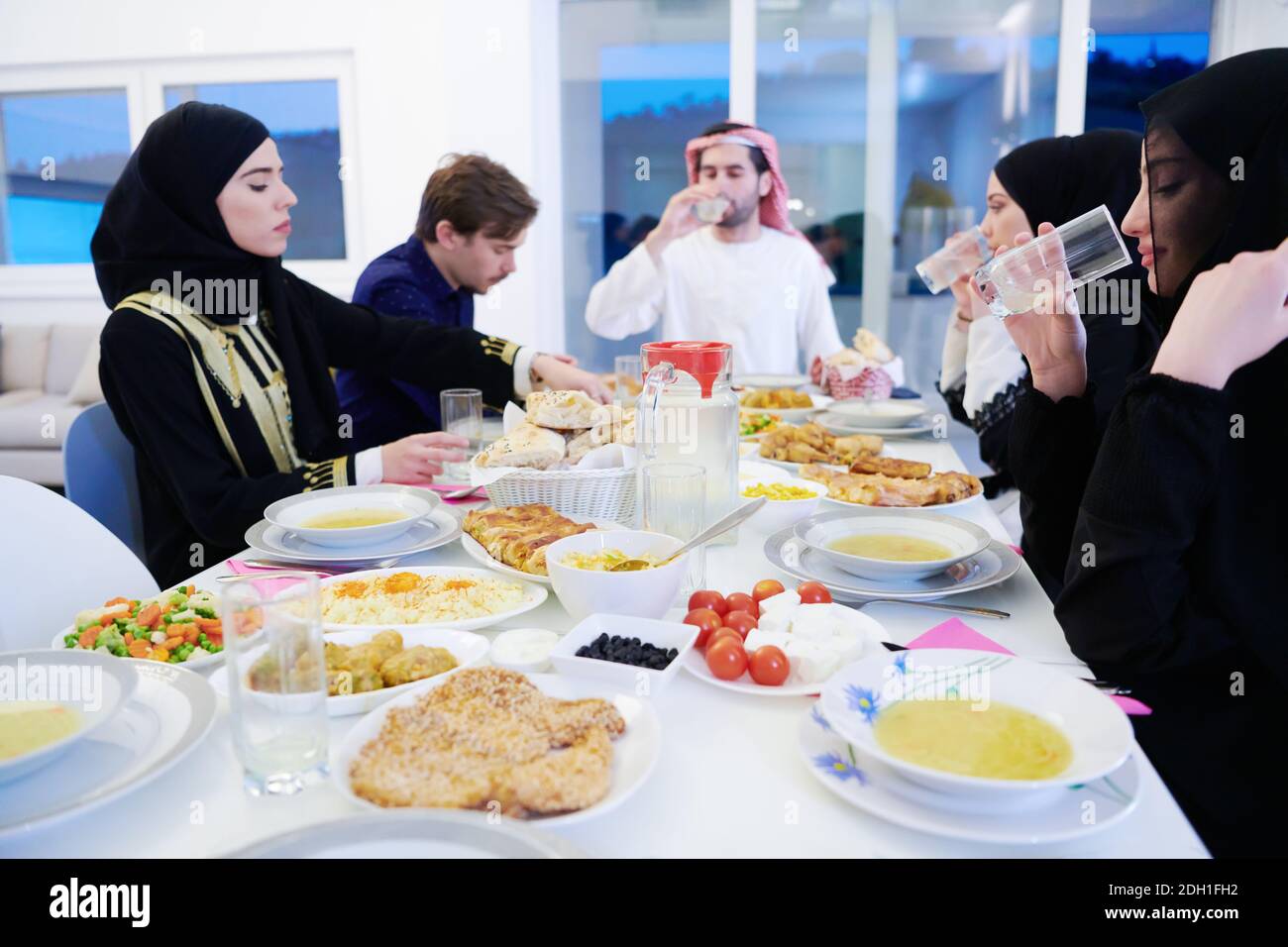 Muslim family having Iftar dinner drinking water to break feast Stock ...