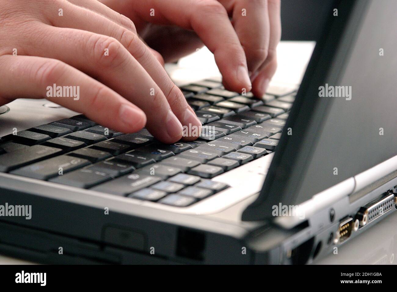 A closeup of a man's hands as he types on his laptop computer keyboard ...