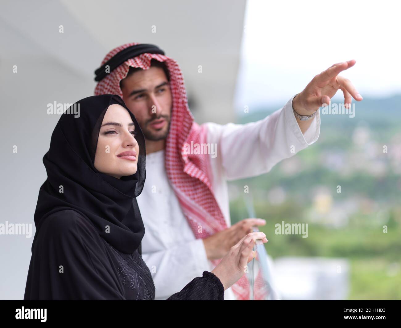 Portrait of beautiful arabian couple standing on balcony Stock Photo ...