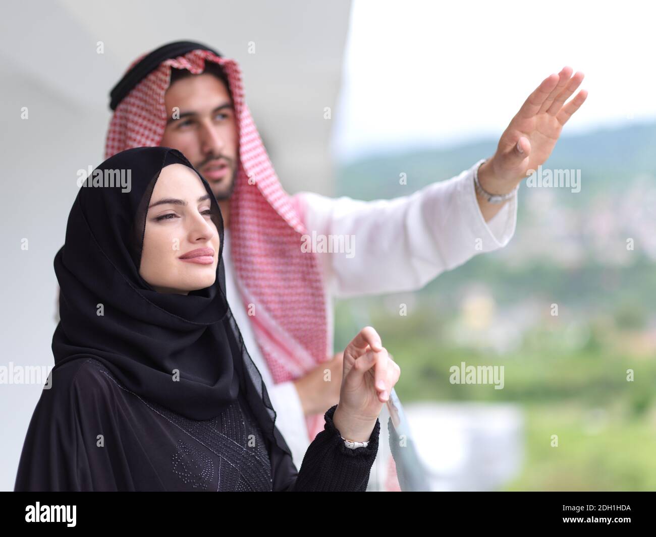 Portrait of beautiful arabian couple standing on balcony Stock Photo ...
