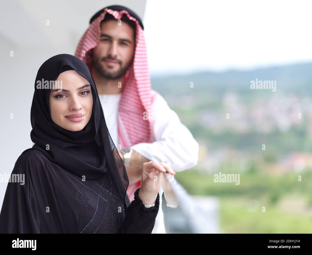 Portrait of beautiful arabian couple standing on balcony Stock Photo ...