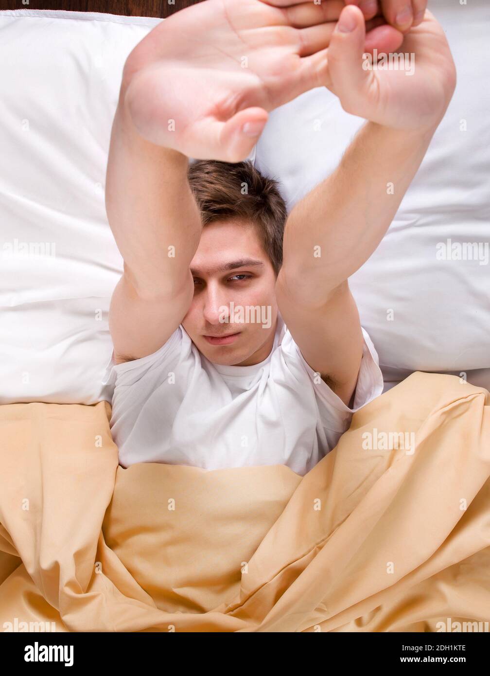 Young Man wake up in the Bed at the Home Stock Photo - Alamy