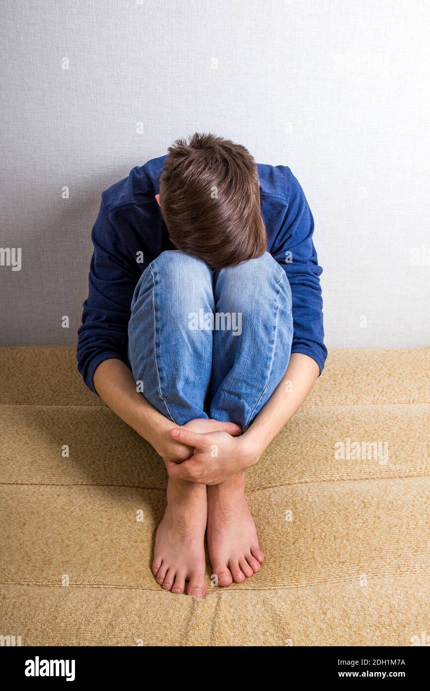 Sad Young Man on the Couch in the Room Stock Photo - Alamy
