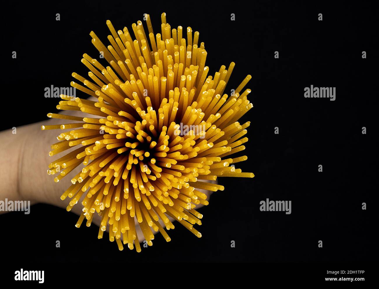 View from above of a hand holding spaghetti on black background Stock ...