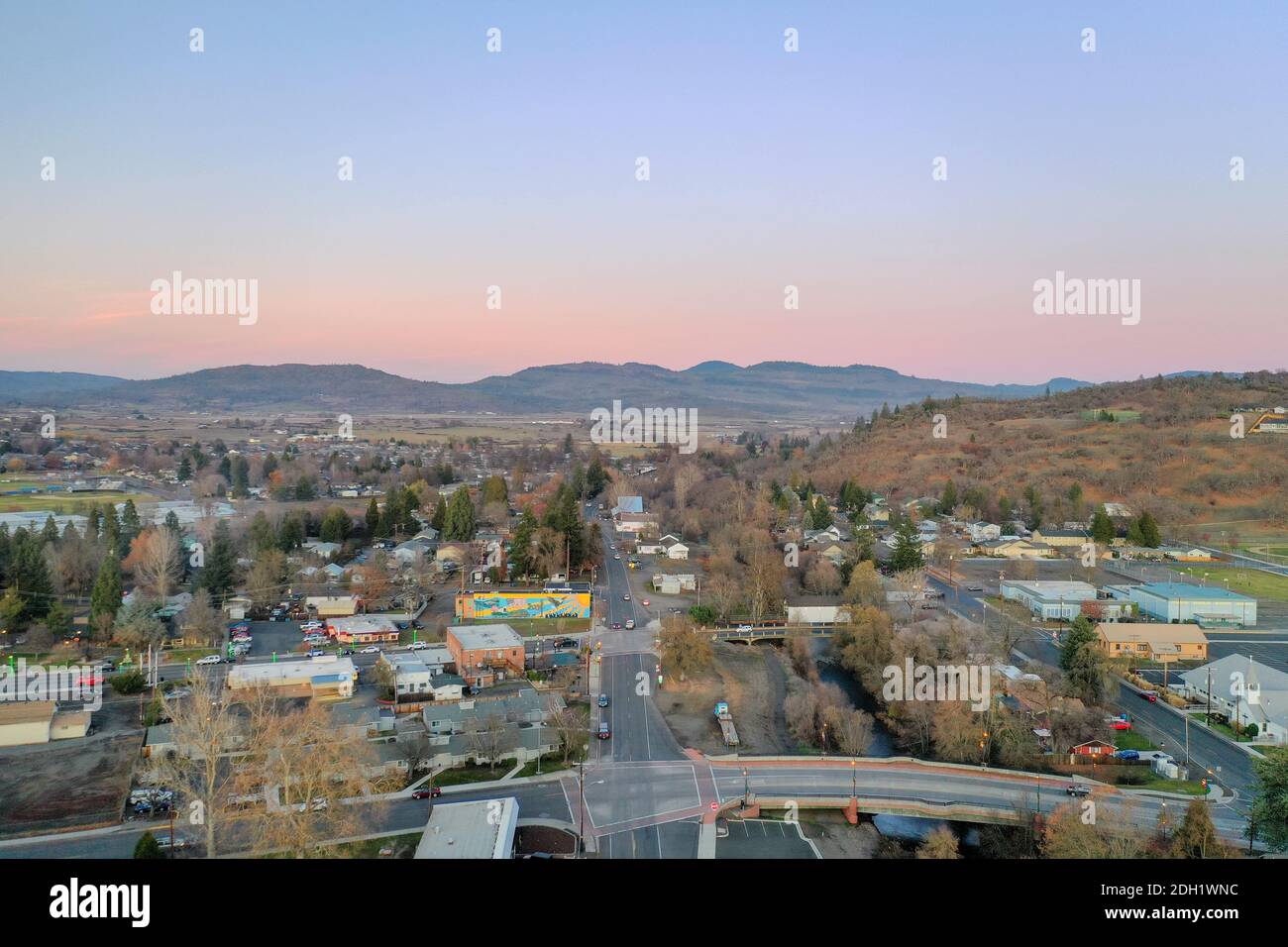 Peaceful town surrounded by trees with mountains as background Stock ...