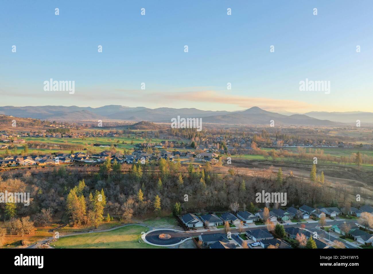 Peaceful town surrounded by trees with mountains as background Stock ...