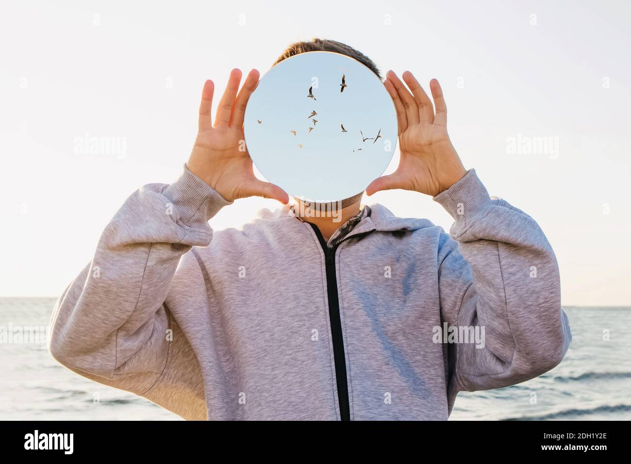 Creative concept. Man holds mirror near his face with reflection of ...