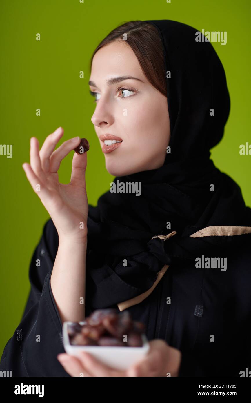 Woman in Abaya Holding a Date Fruit and glass of water Stock Photo - Alamy