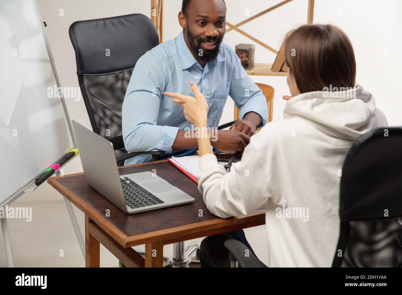 Giving a lesson, talking. English courses at home. Smiling man teaches ...