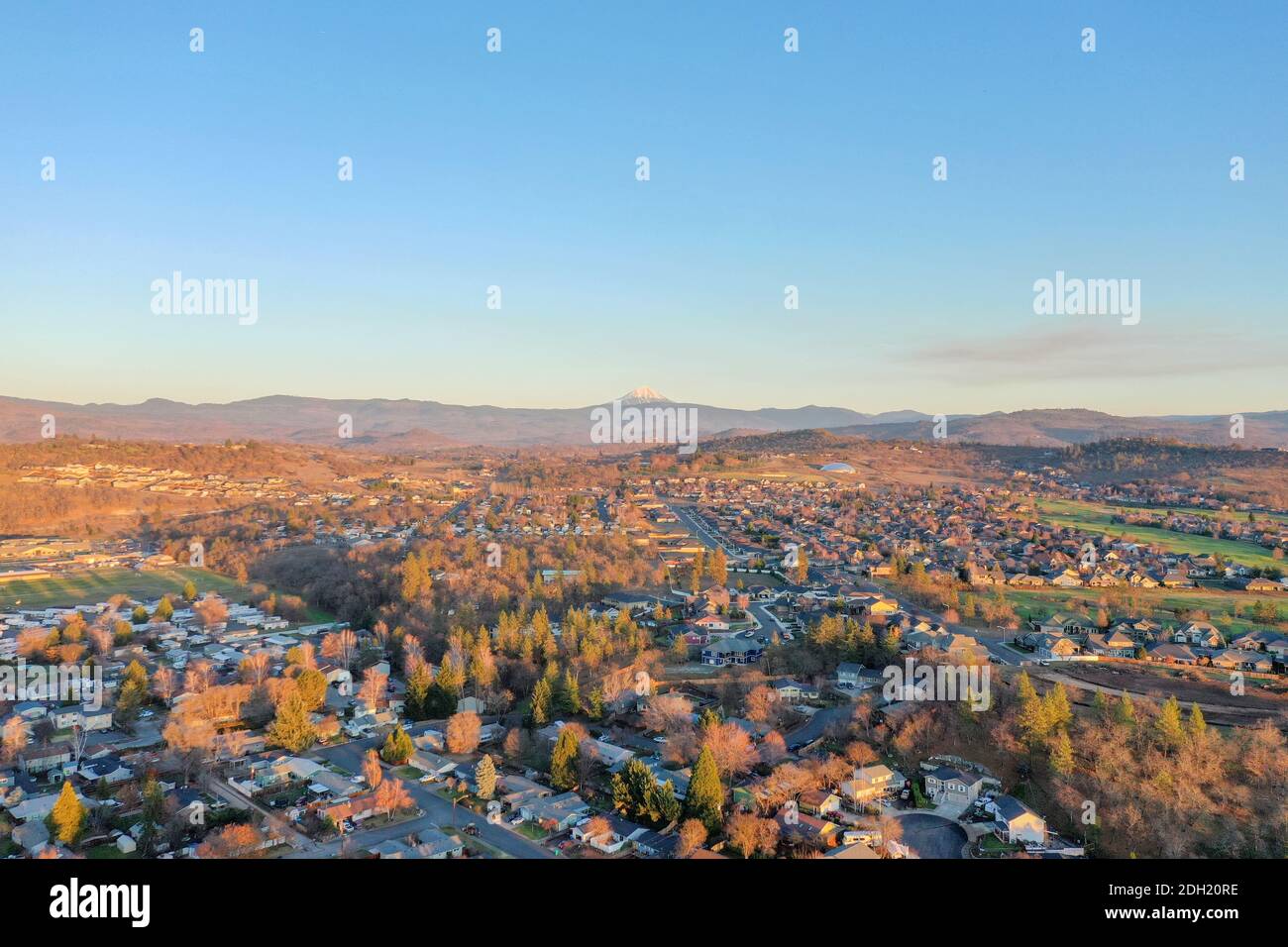 Peaceful town surrounded by trees with mountains as background Stock ...