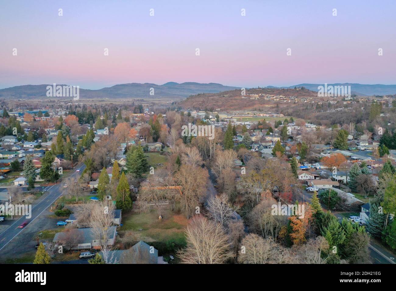 Peaceful town surrounded by trees with mountains as background Stock ...