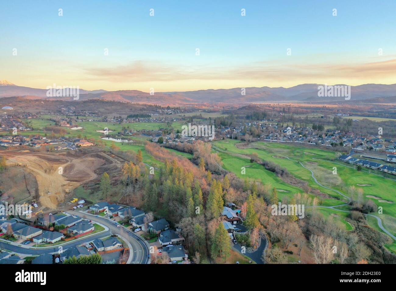 Peaceful town surrounded by trees with mountains as background Stock ...