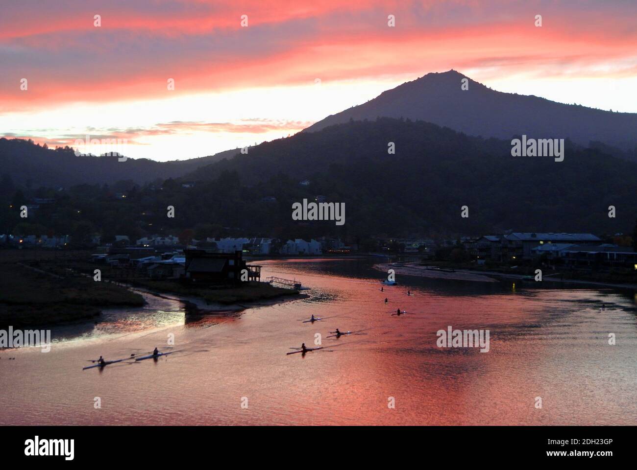 kayakers paddle on corte madera creek at sunset under mount talmalpais ...