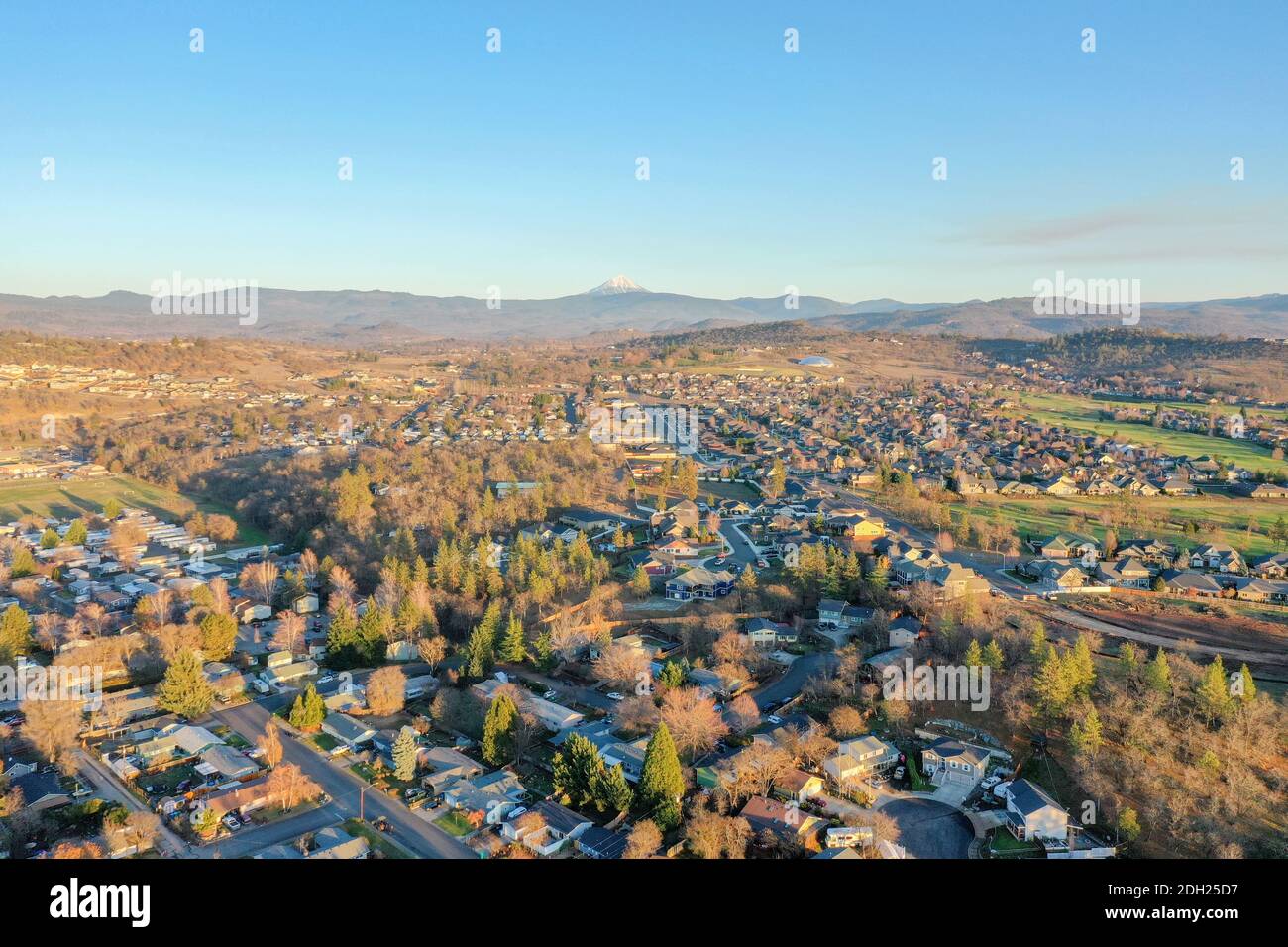 Peaceful town surrounded by trees with mountains as background Stock ...