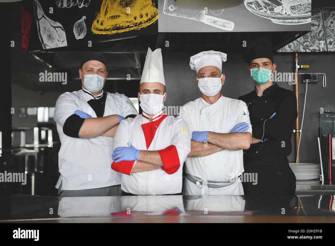 Group chefs standing together in the kitchen at restaurant wearing ...
