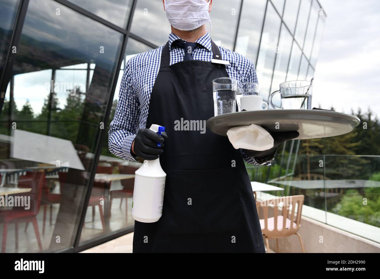 Waiter cleaning the table with Disinfectant Spray in a restaurant Stock ...
