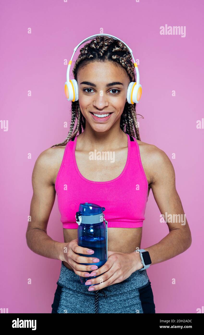 Beautiful girl doing exercises and sport. Posing on a pink colored ...